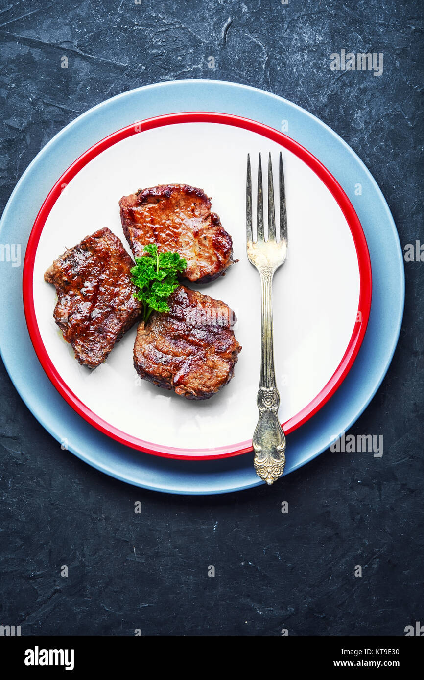 Three grilled steak of beef on the plate Stock Photo - Alamy