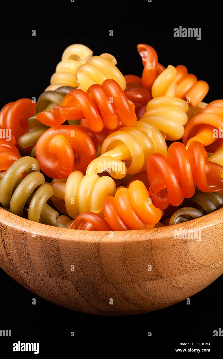 Spiral pasta trottole tricolore isolated in wooden bowl on black ...