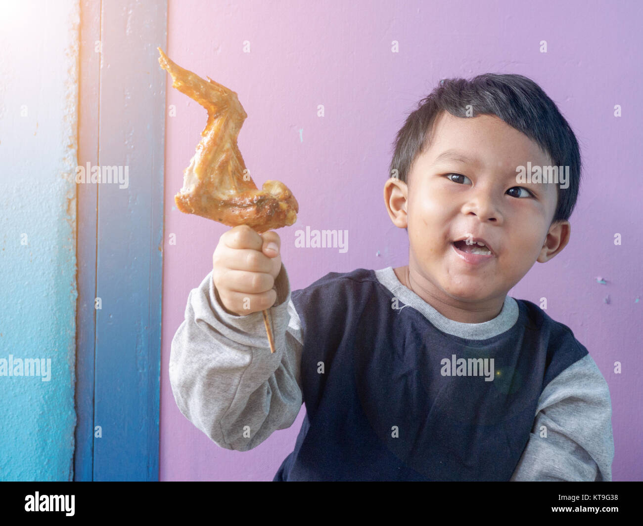asian boy eating roasted chicken wing Stock Photo - Alamy
