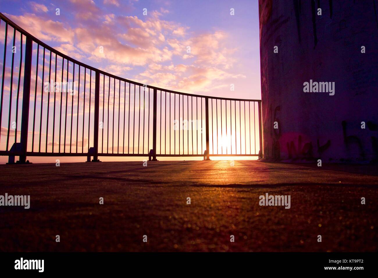 Sunset sky with orange clouds behind balcony railings shot from low ...