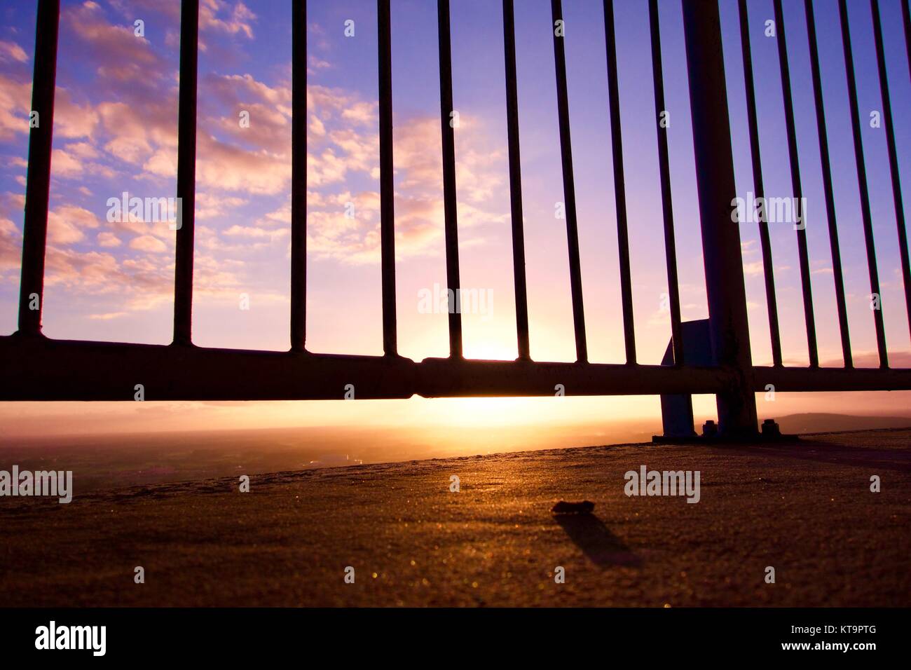 Sunset sky with orange clouds behind balcony railings shot from low ...