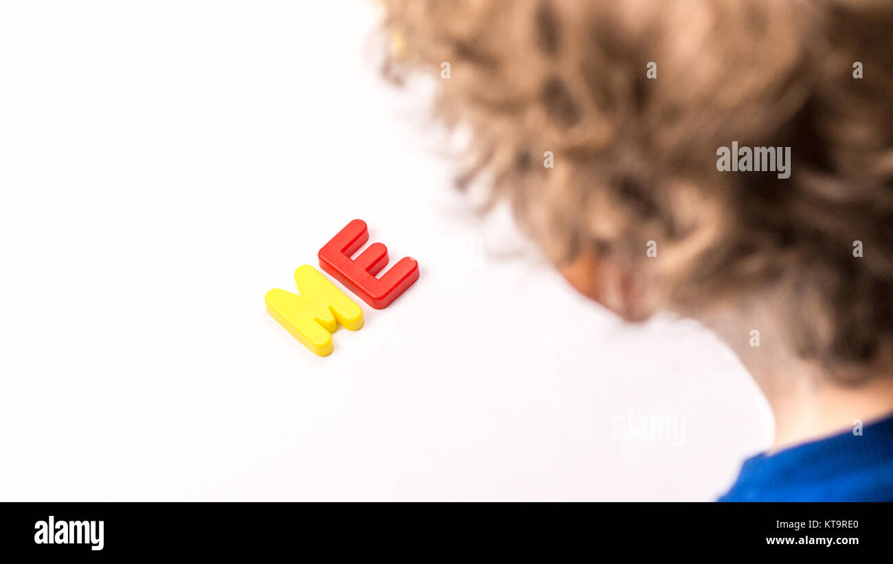 child is looking at a word me on white background word me on white ...