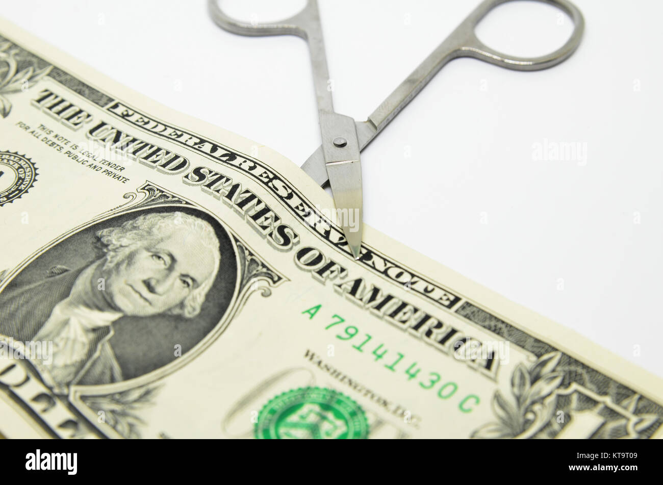Scissors cut through a dollar bill Stock Photo - Alamy