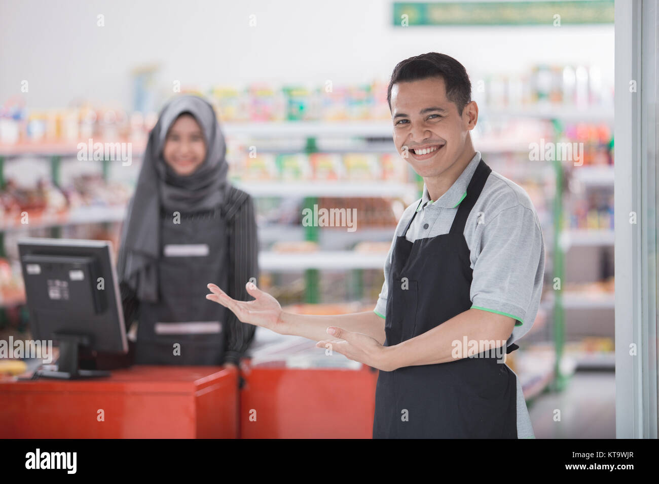 happy young male shopkeeper welcoming customer Stock Photo - Alamy happy young male shopkeeper welcoming customer Stock Photo - Alamy