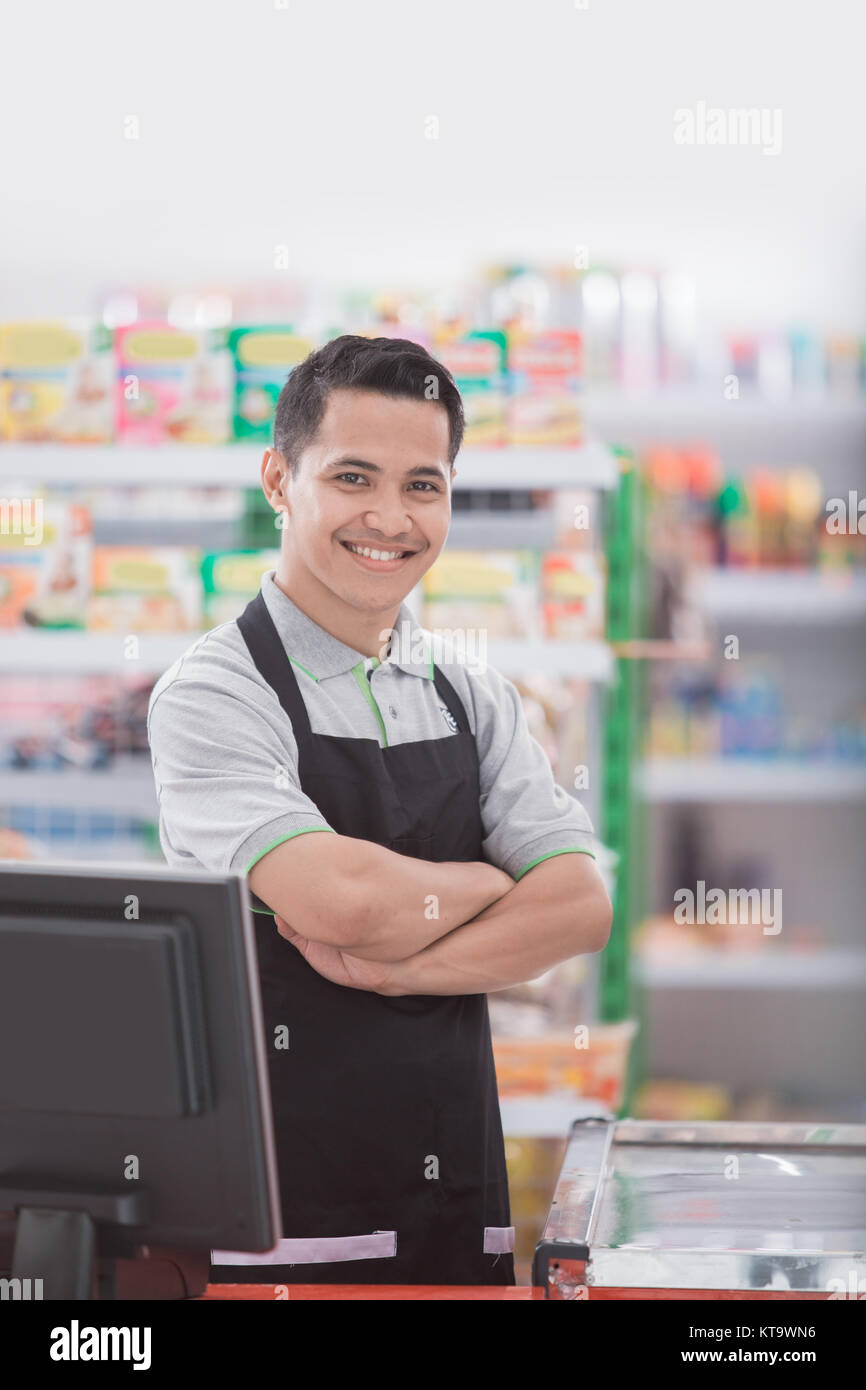 Portrait of a smiling shopkeeper in a grocery store Stock Photo - Alamy