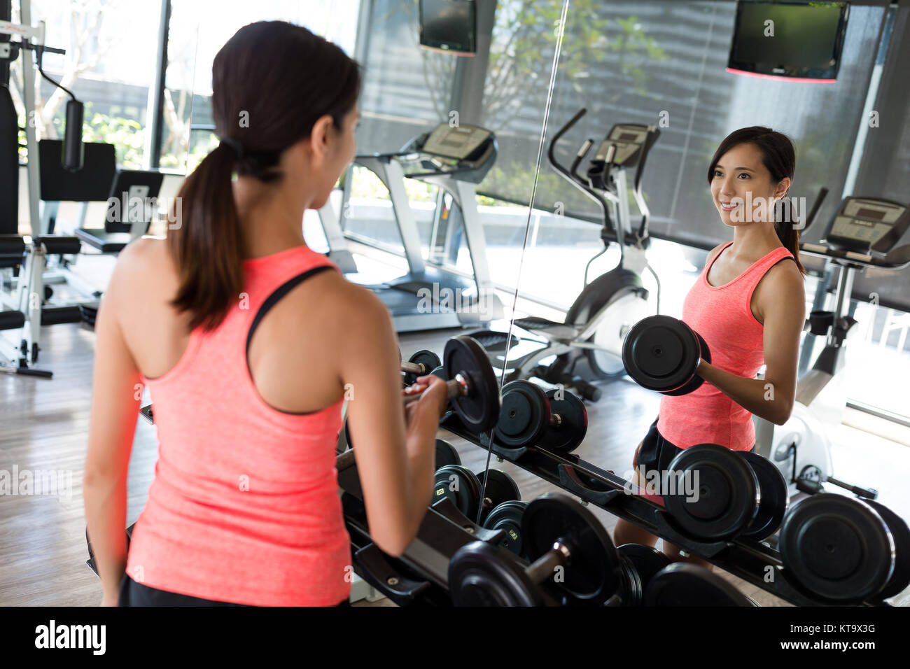 Woman training on dumbbell inside gym room Stock Photo - Alamy