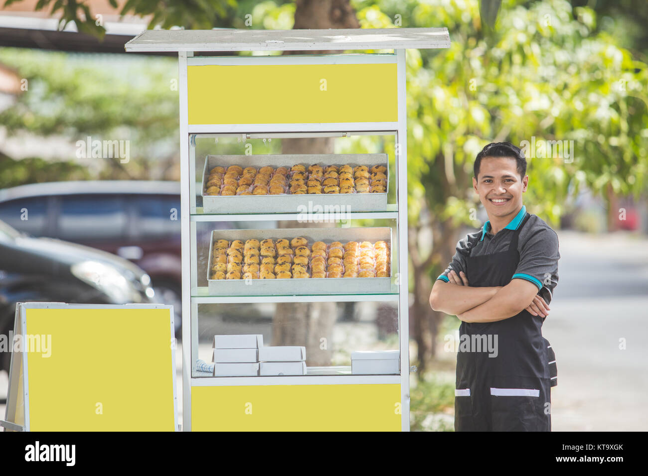 small business owner standing proudly in front of his food stall ...