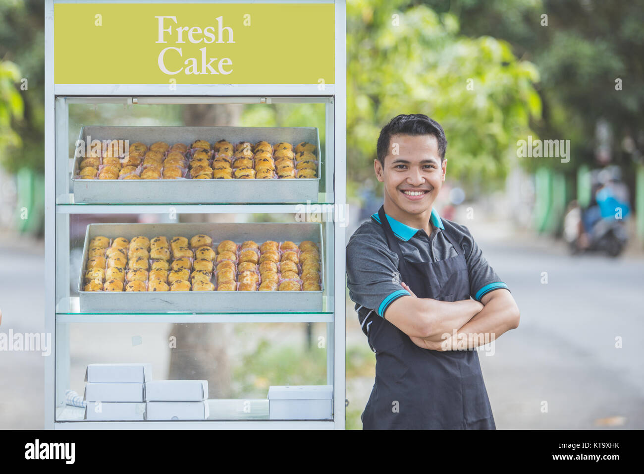 small business owner standing proudly in front of his food stall ...