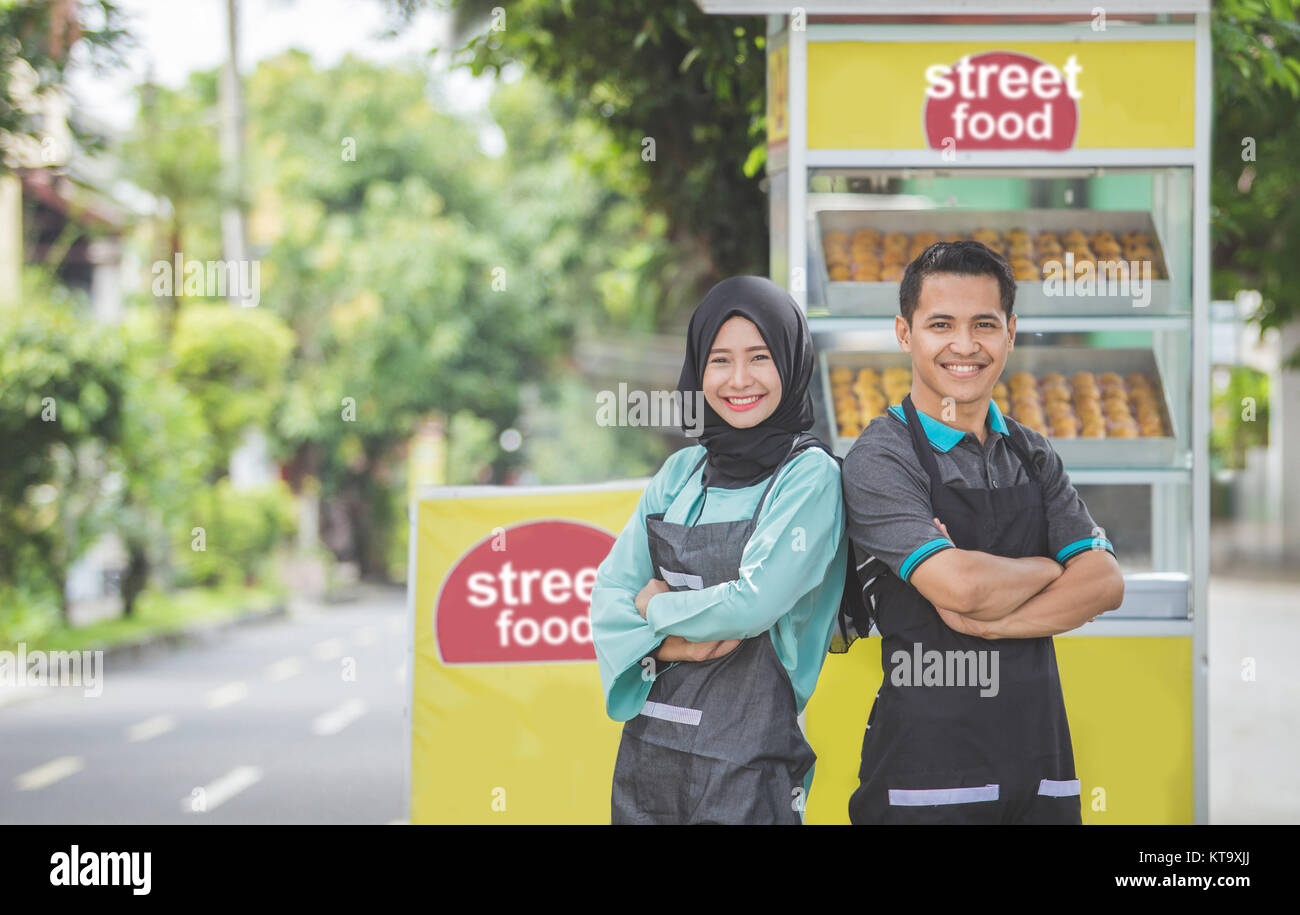 asian man business owner standing at his food kiosk on the side of the ...