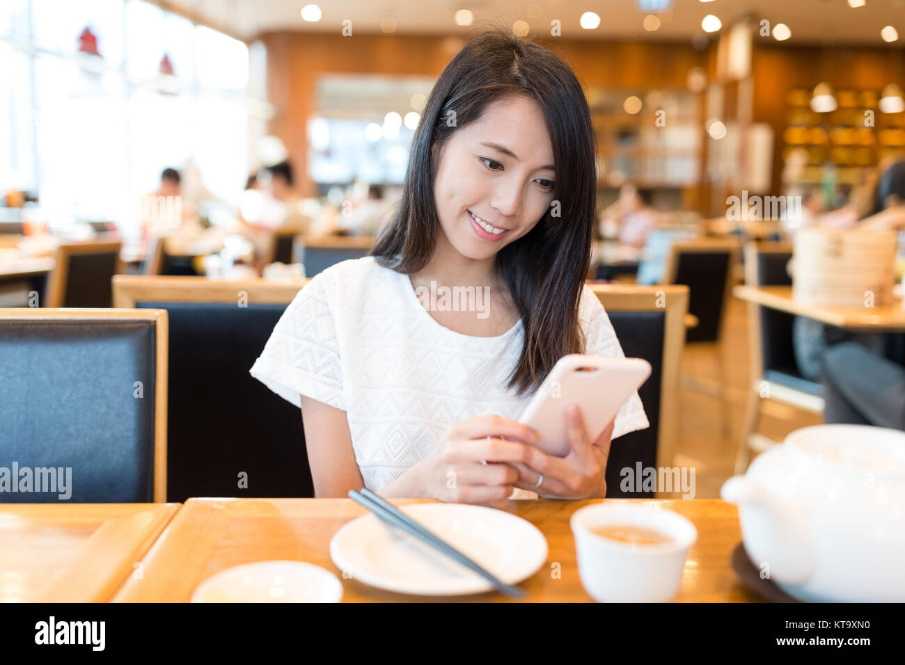 Woman use of mobile phone in chinese restaurant Stock Photo - Alamy
