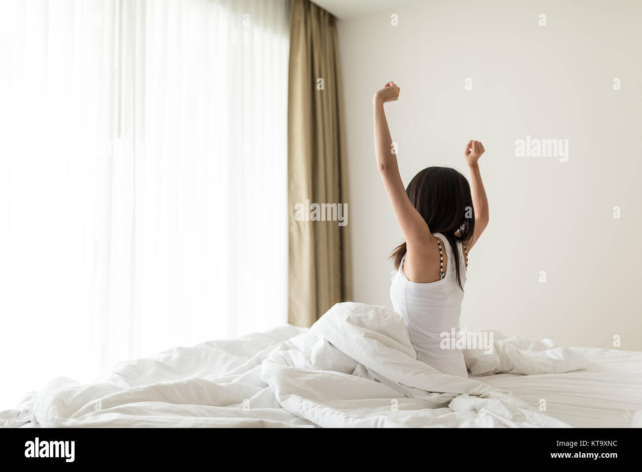 Woman stretching in bed after wake up Stock Photo - Alamy