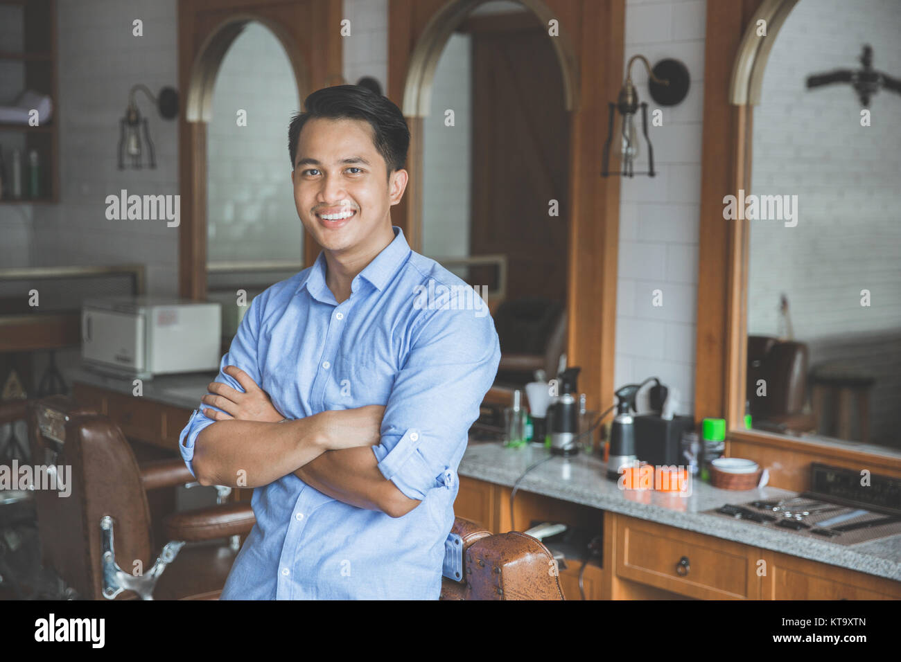 Confident barber expert. Young man looking at camera and smiling ... Confident barber expert. Young man looking at camera and smiling ...