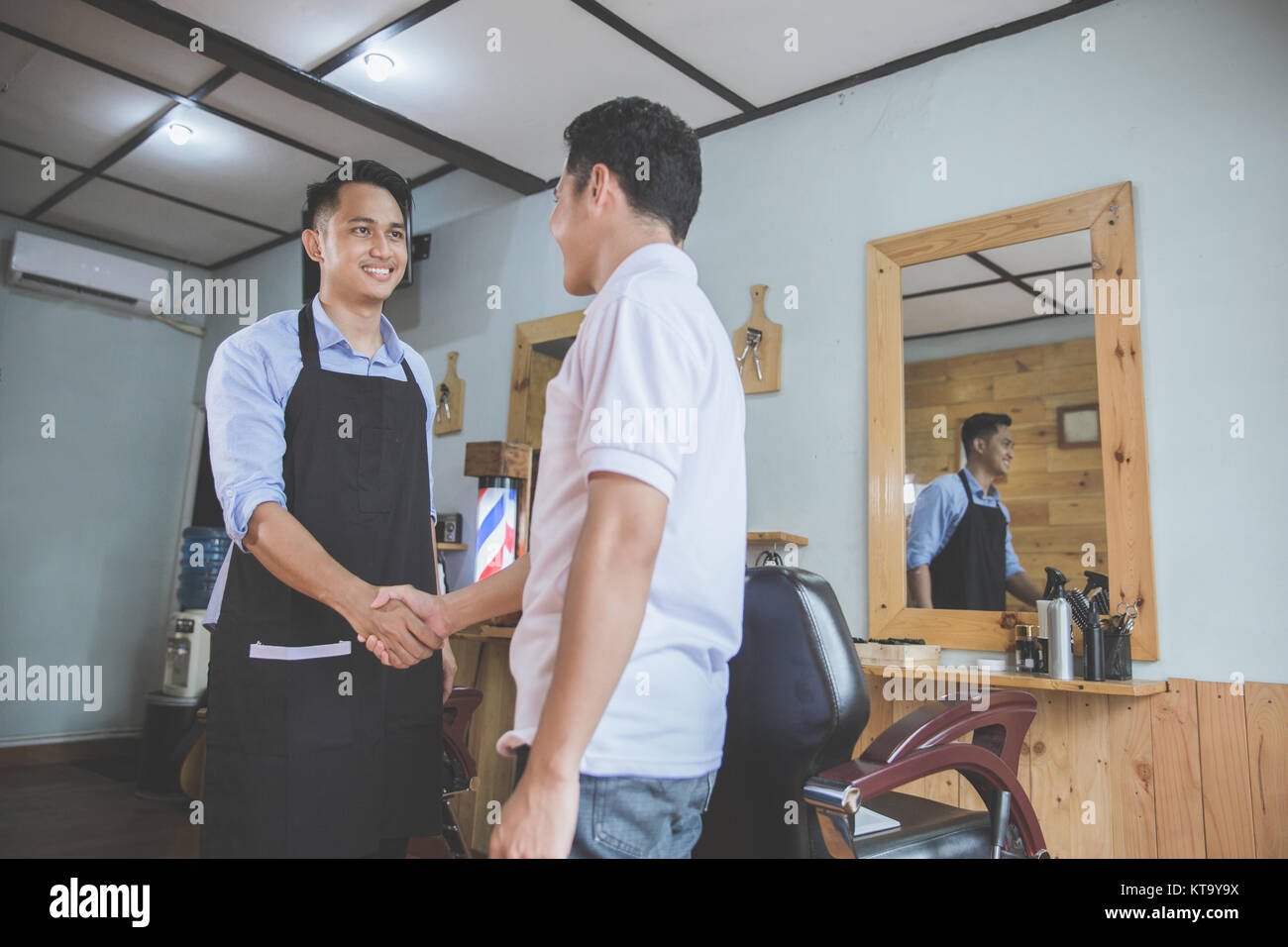 Handshake at barbershop. barber and his client shaking hands while ...