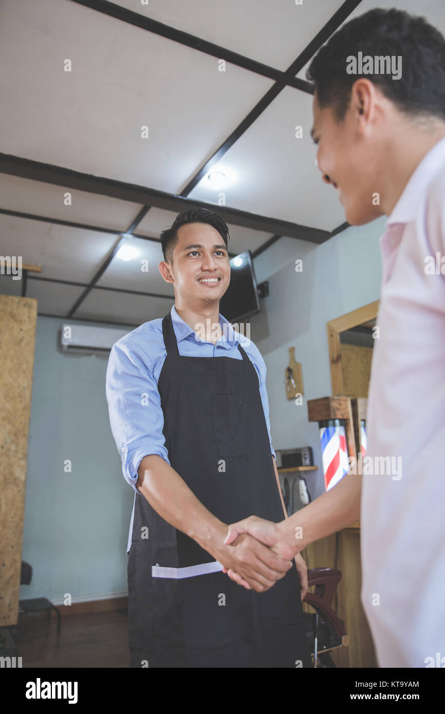 Handshake at barbershop. barber and his client shaking hands while ...
