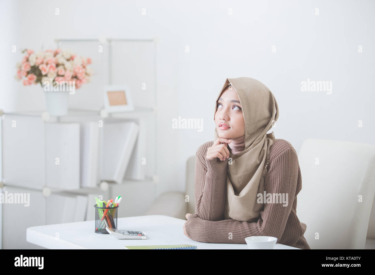 portrait of young female student thinking and looking up to copyspace ...