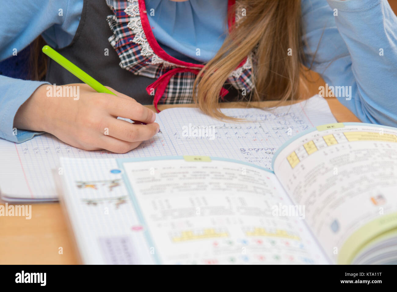 A pupil in class writing in a notebook, close-up Stock Photo - Alamy