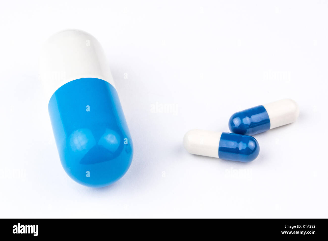 one big capsule looking like a big blue and white pill two little pills ...