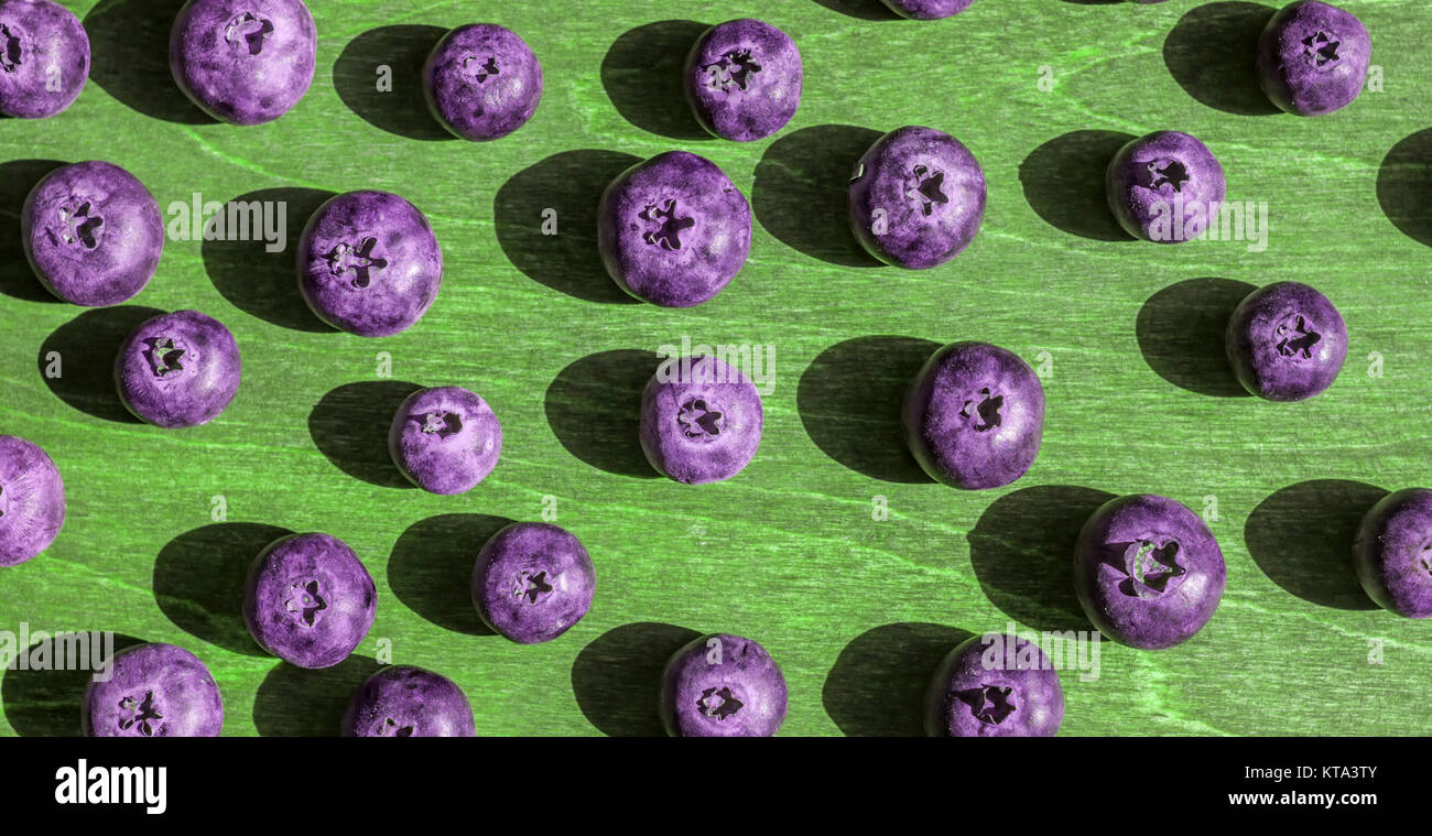 violet blueberries green background bright shadows Stock Photo - Alamy