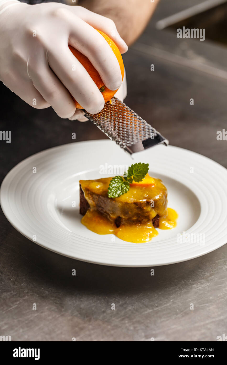 Chef rasping orange zest Stock Photo - Alamy