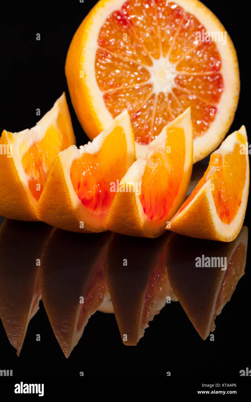 Slices of red orange isolated on black background Stock Photo - Alamy