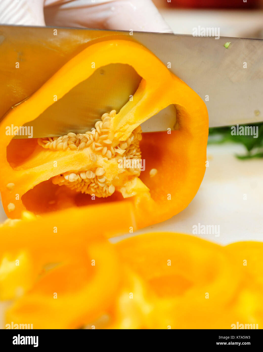 Yellow pepper being sliced with a knife Stock Photo - Alamy
