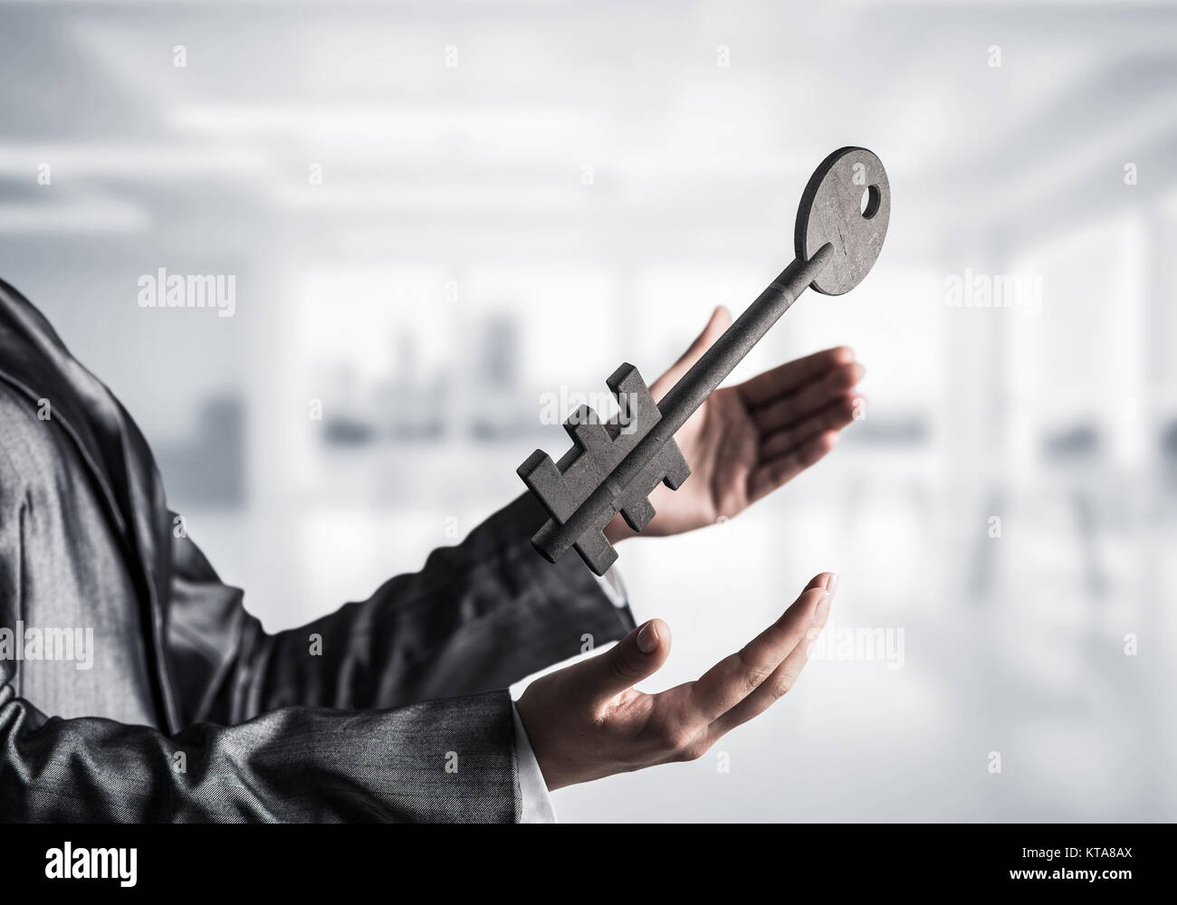 Business woman in black suit keeping big stone key in hands with office ...