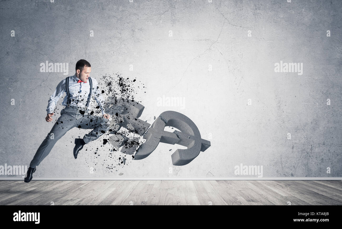 Young furious businessman jumping and crashing with kick stone dollar ...