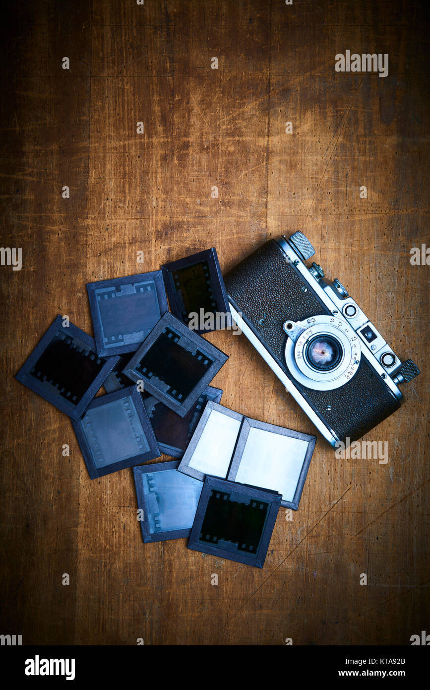 Vintage photo film camera with group of slides on a scratched old ...