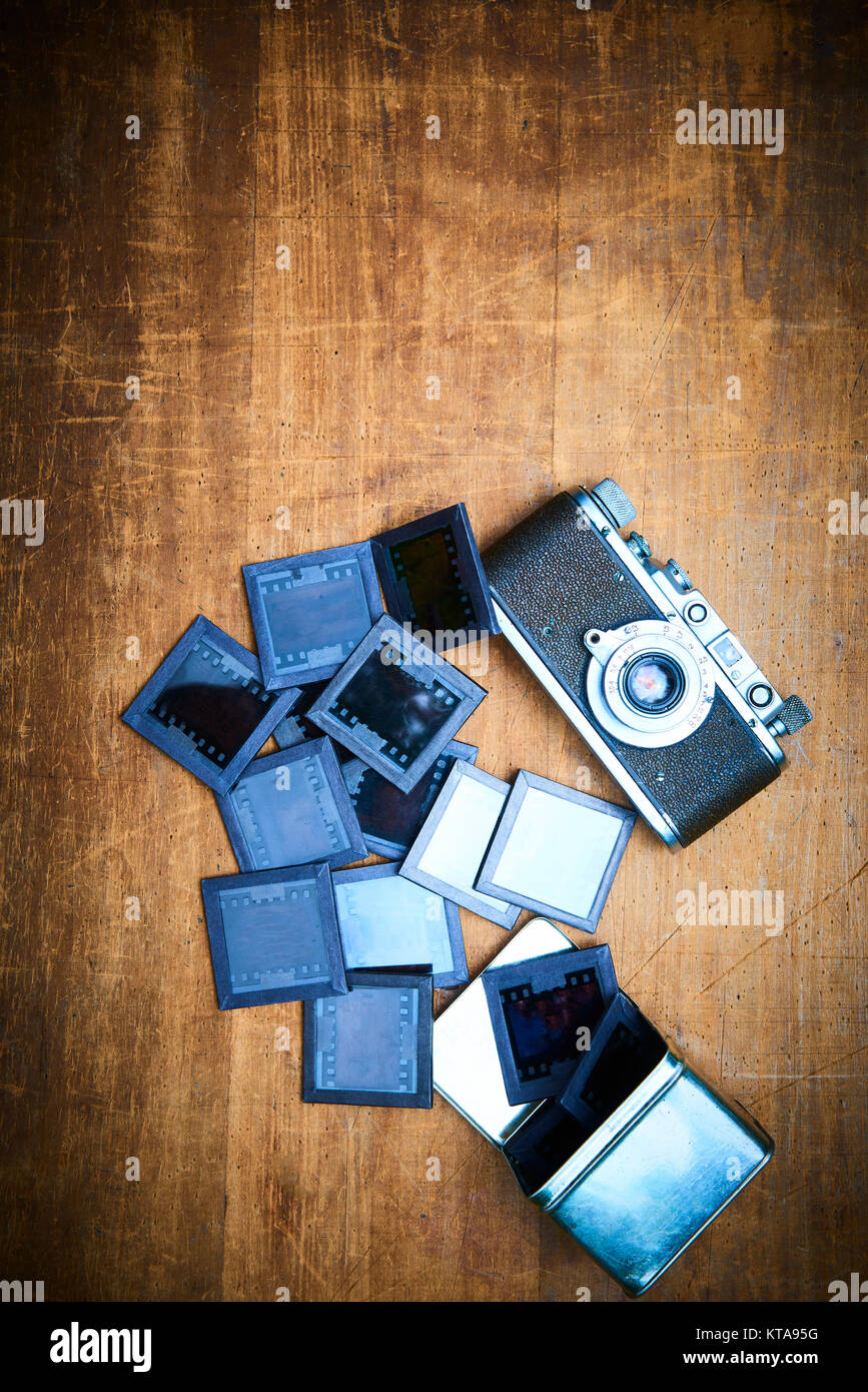 Vintage photo film camera with group of slides on a scratched old ...