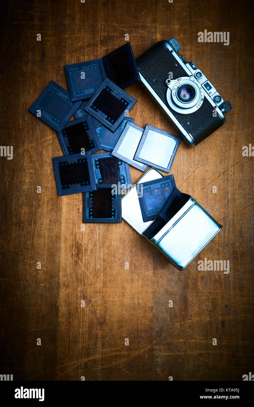 Vintage photo film camera with group of slides on a scratched old ...