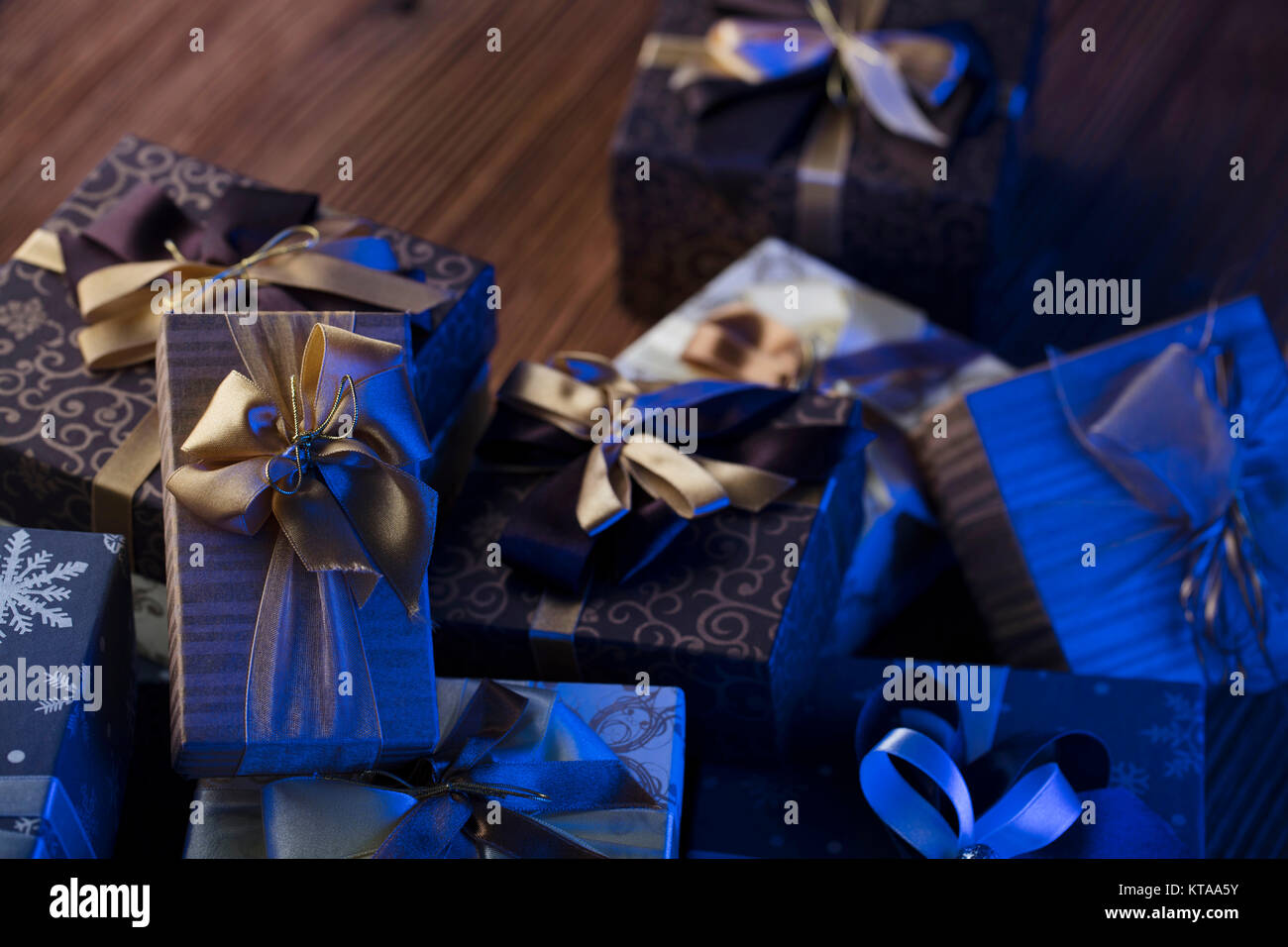 Presents in blue and gold aesthetics, rustic wooden table. Place for ...