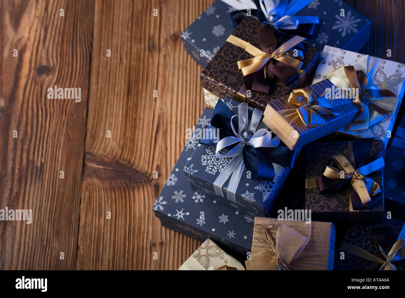 Presents in blue and gold aesthetics, rustic wooden table. Place for ...