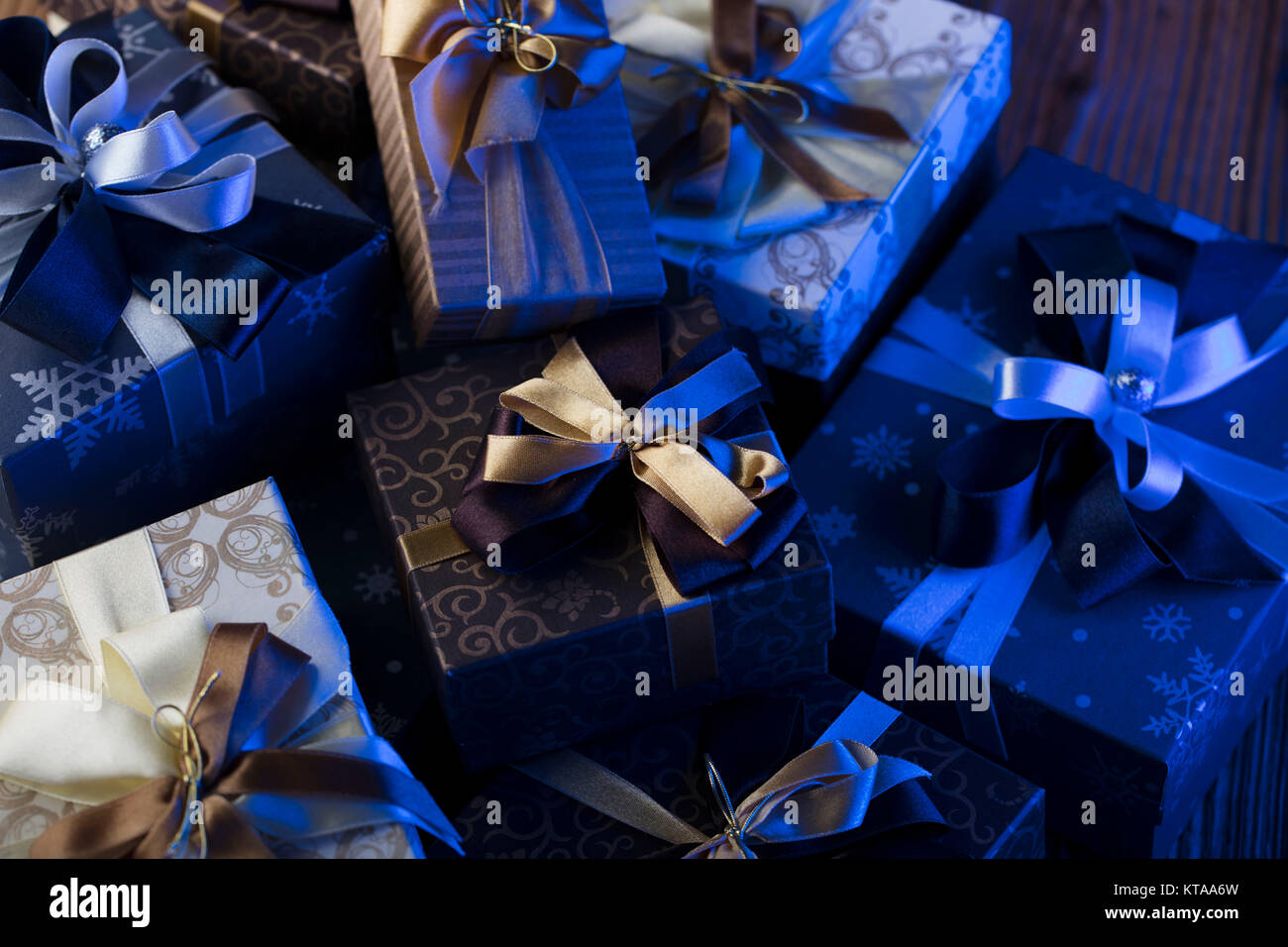 Presents in blue and gold aesthetics, rustic wooden table. Place for ...