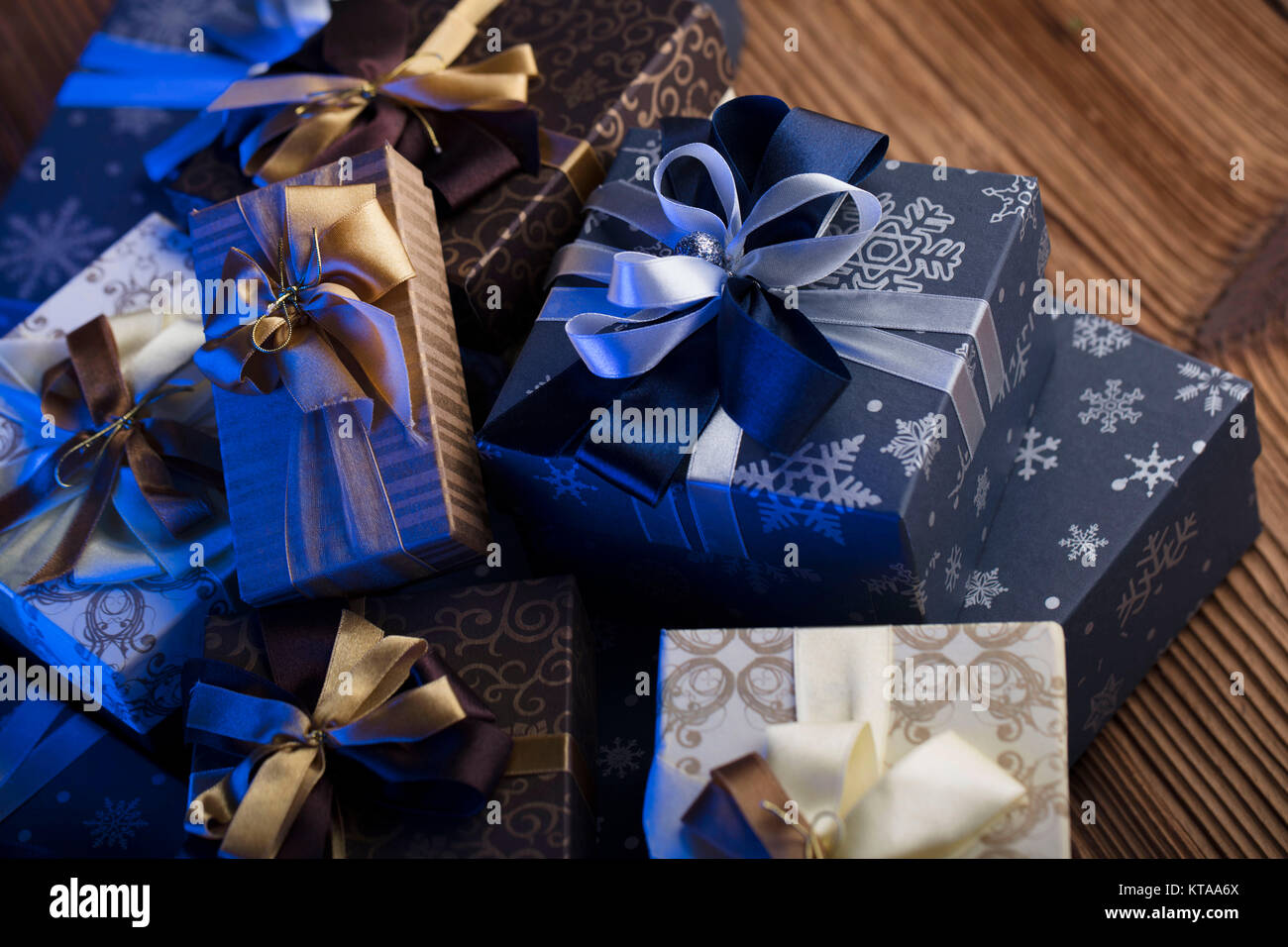 Presents in blue and gold aesthetics, rustic wooden table. Place for ...