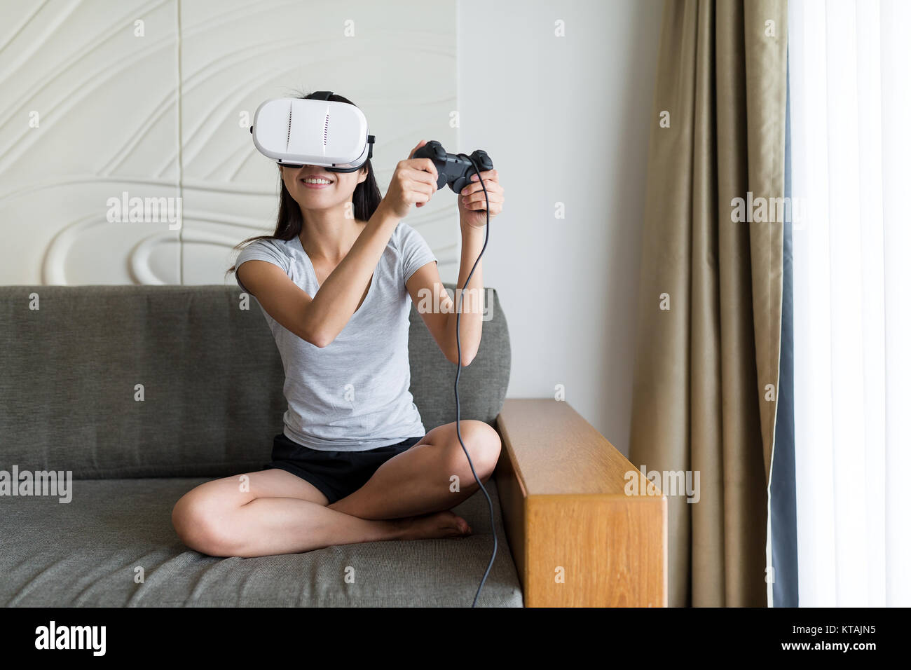 Woman play game with virtual reality and sitting on sofa Stock Photo ...