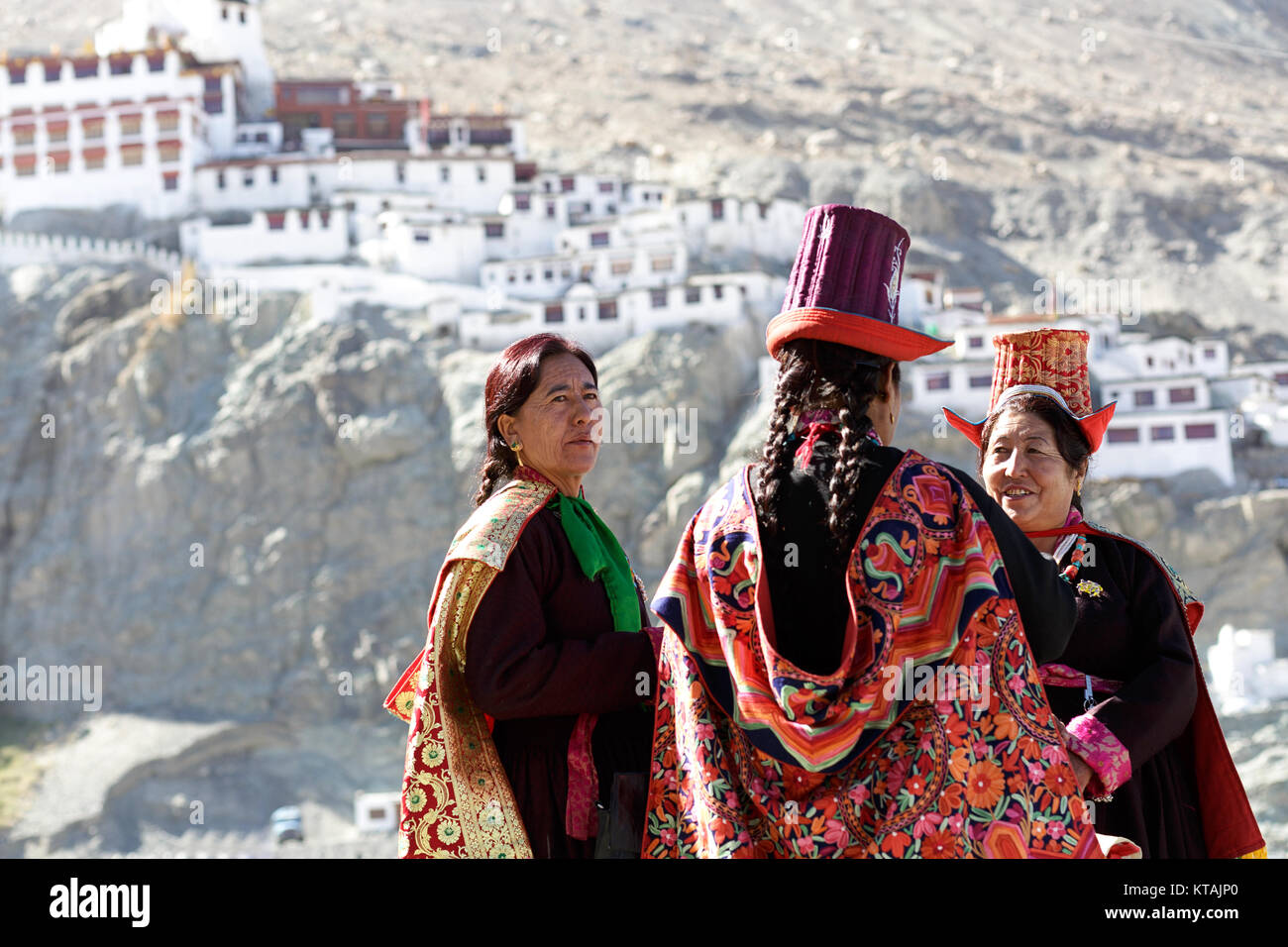 Three ladies in traditional costume and headwear talking at annual ...