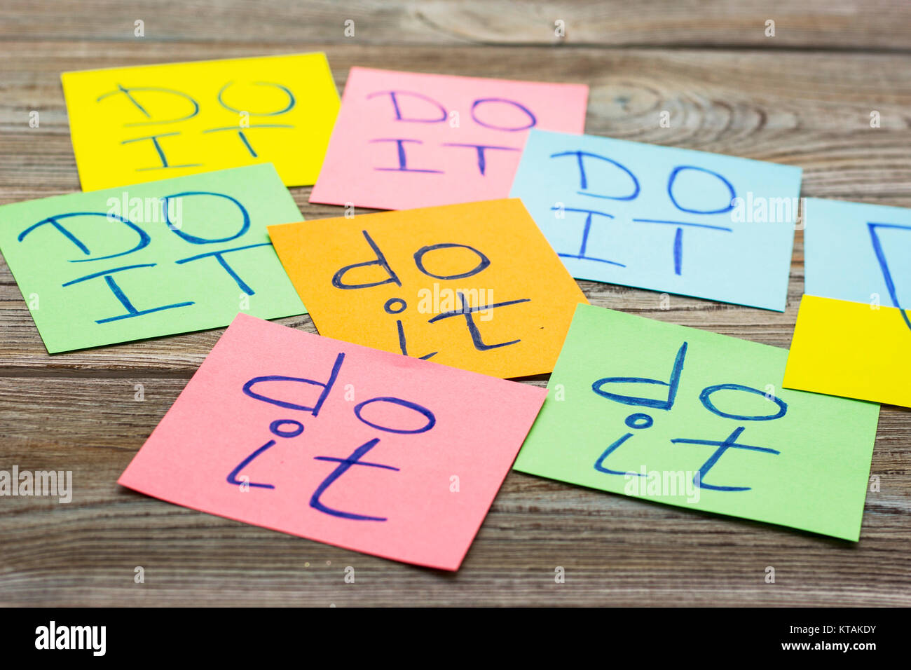 Stick colorful notes inscribed with do it words.Light wooden background ...
