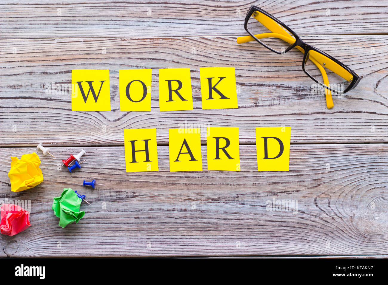 Work hard printed inscription, glasses and balls of crumpled paper on a ...