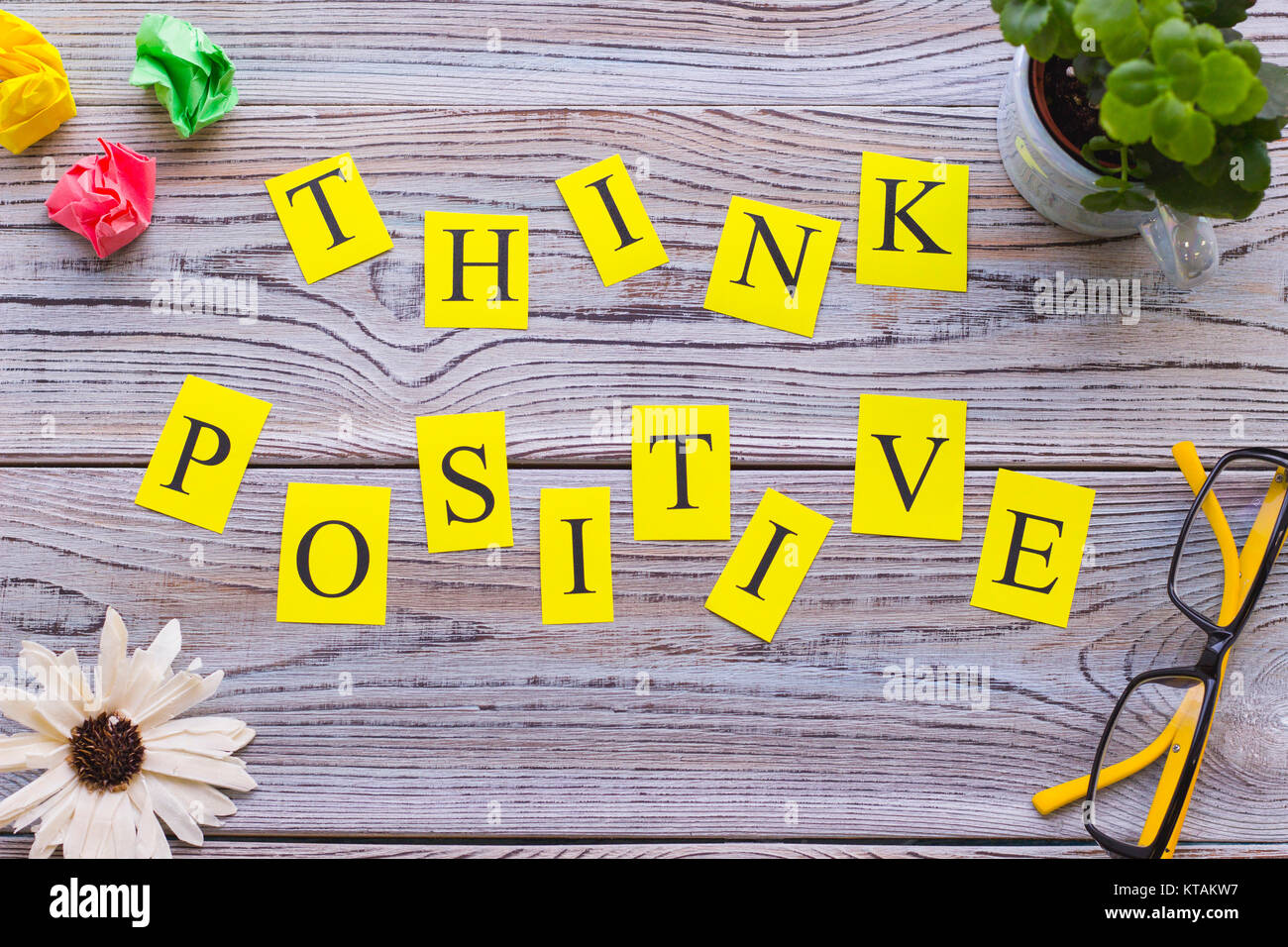 Think positive inscription printed on yellow papers with a frame of ...