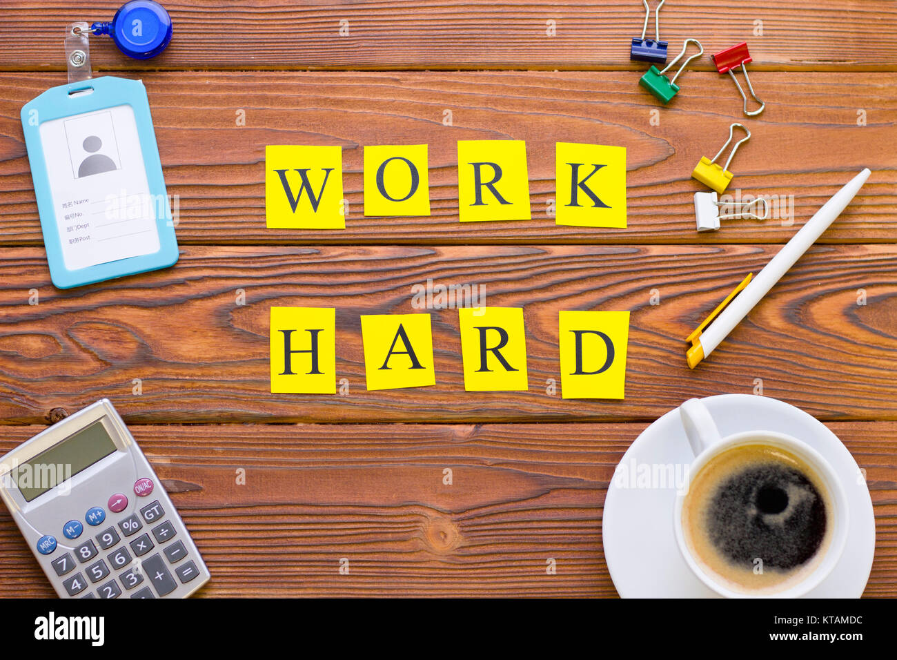 Work hard printed inscription in a frame of office items on a rustic ...