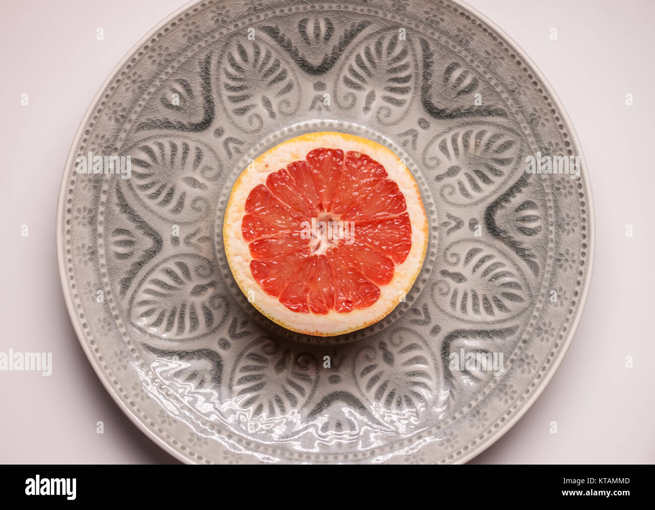 red grapefruit in grey plate Stock Photo - Alamy