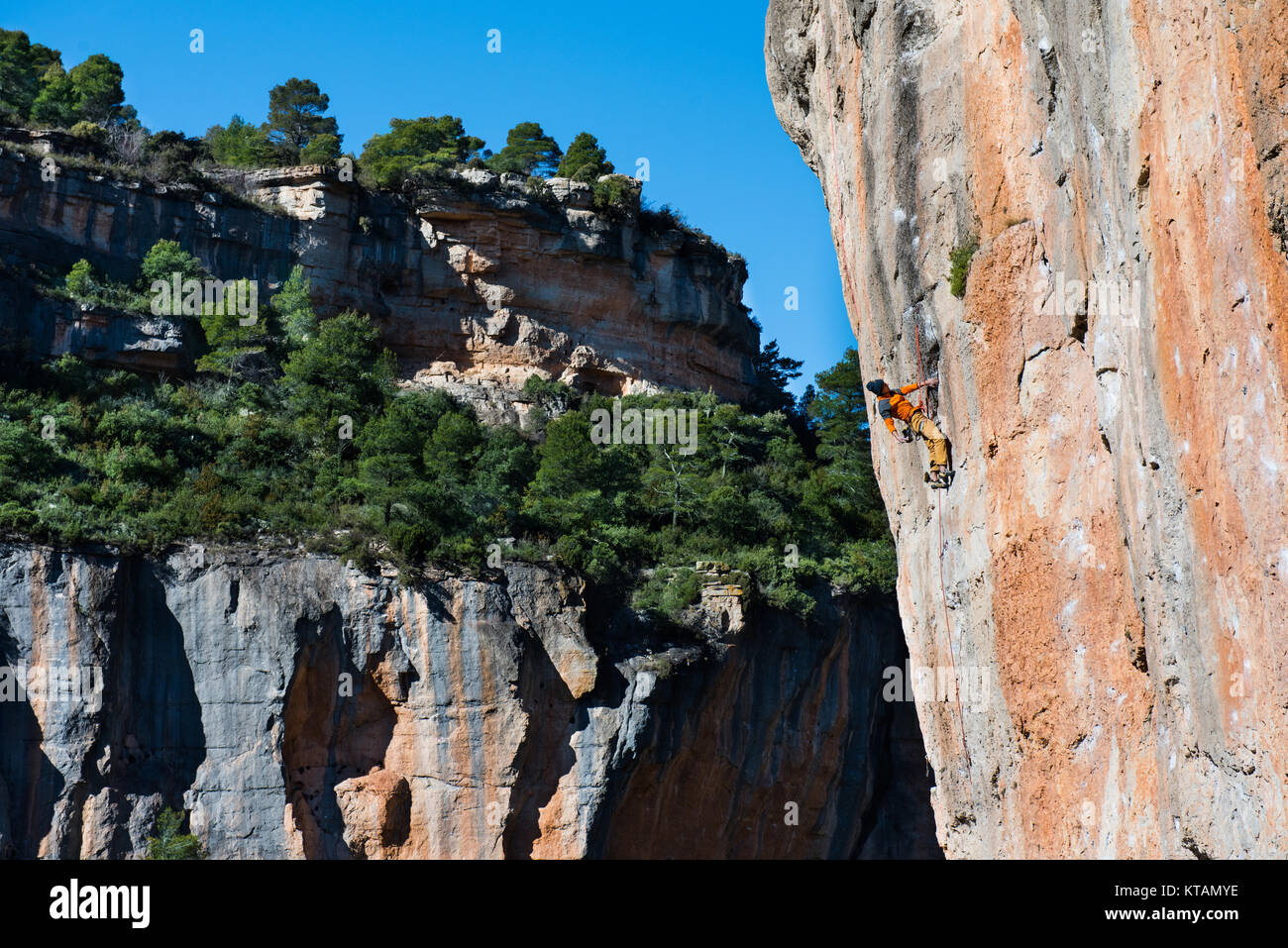 Outdoor sport activity. Rock climber ascending a challenging cliff ...