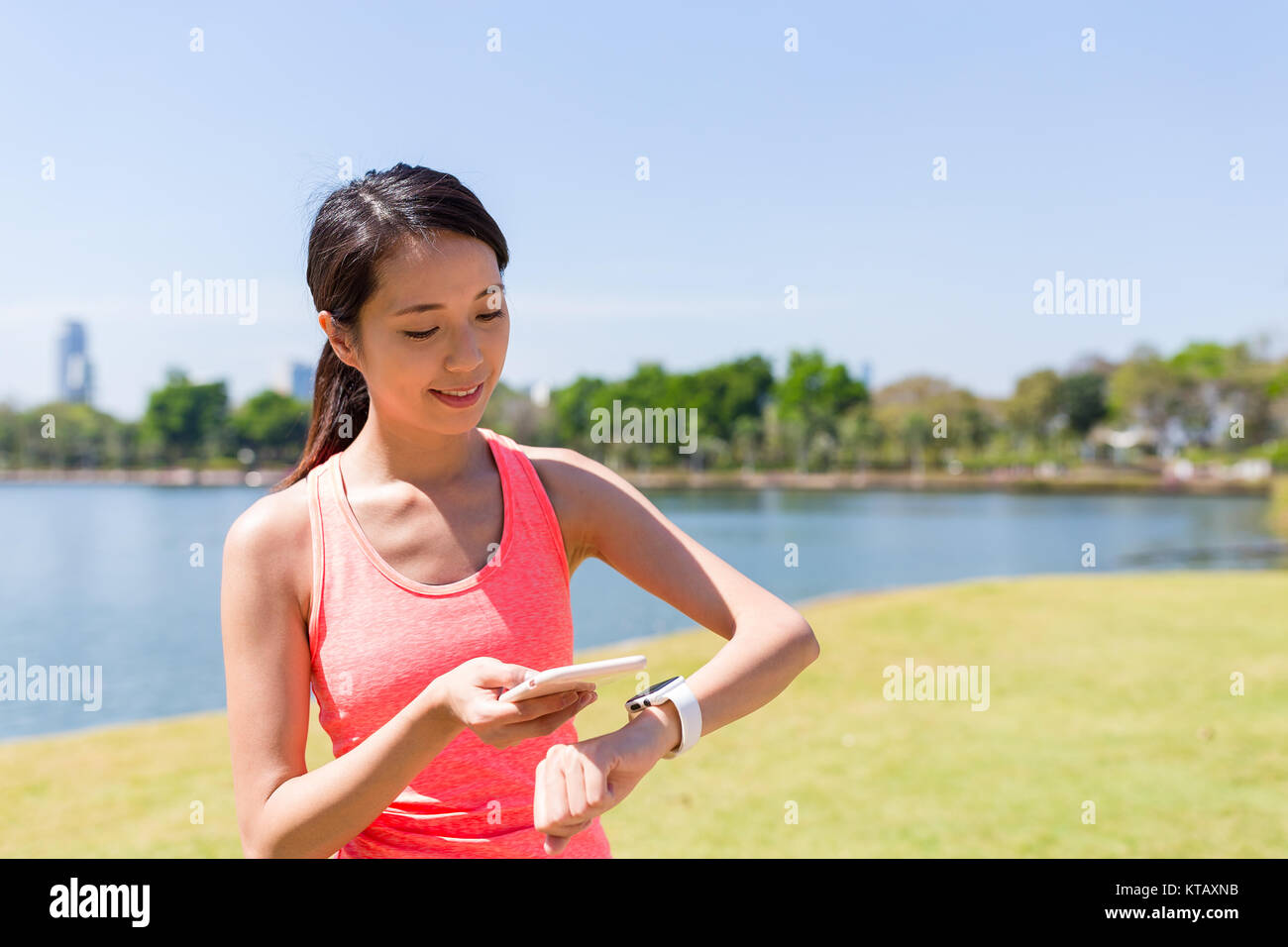 Woman connecting cellphone and smart watch Stock Photo - Alamy