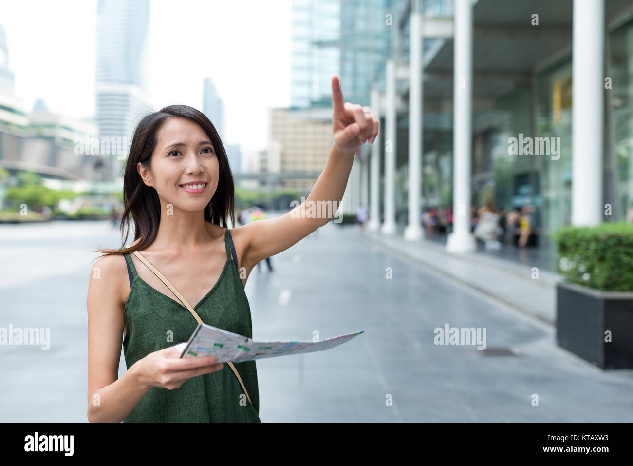 Woman holding city map and finger pointing far away in Bangkok city ...