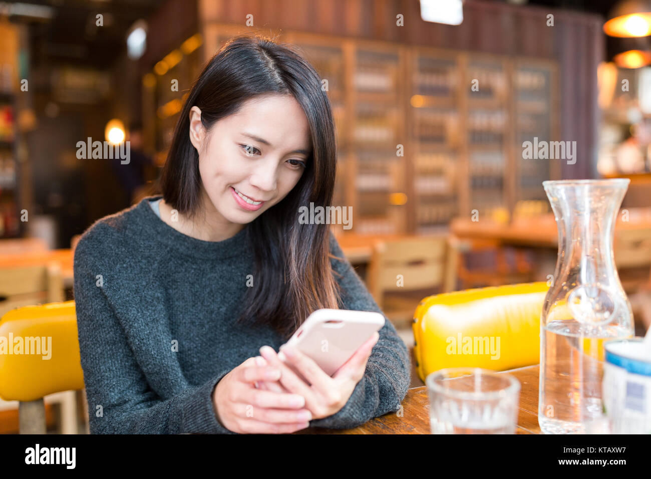 Woman use of mobile phone in restaurant Stock Photo - Alamy