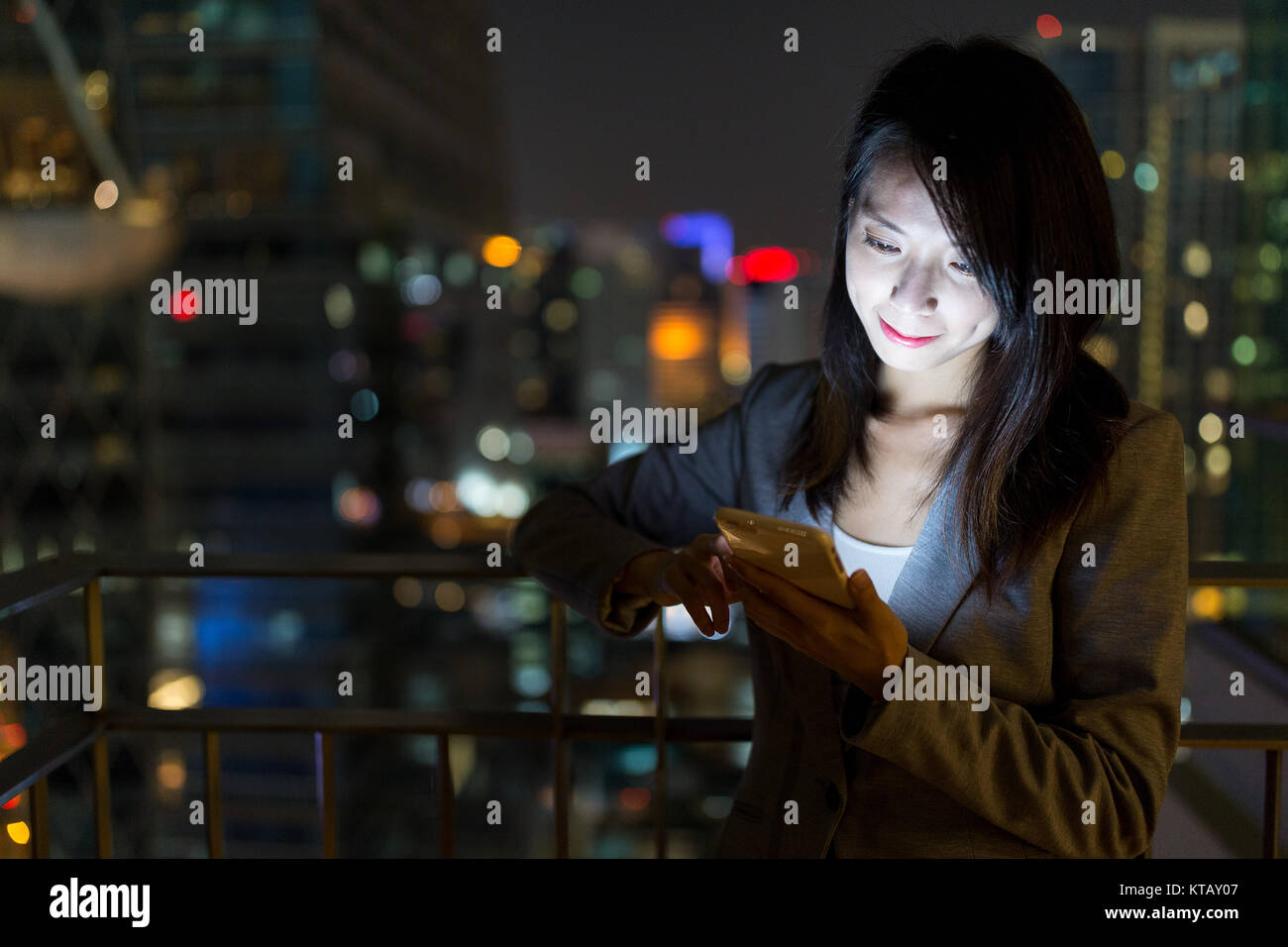 Businesswoman using mobile phone at night Stock Photo - Alamy