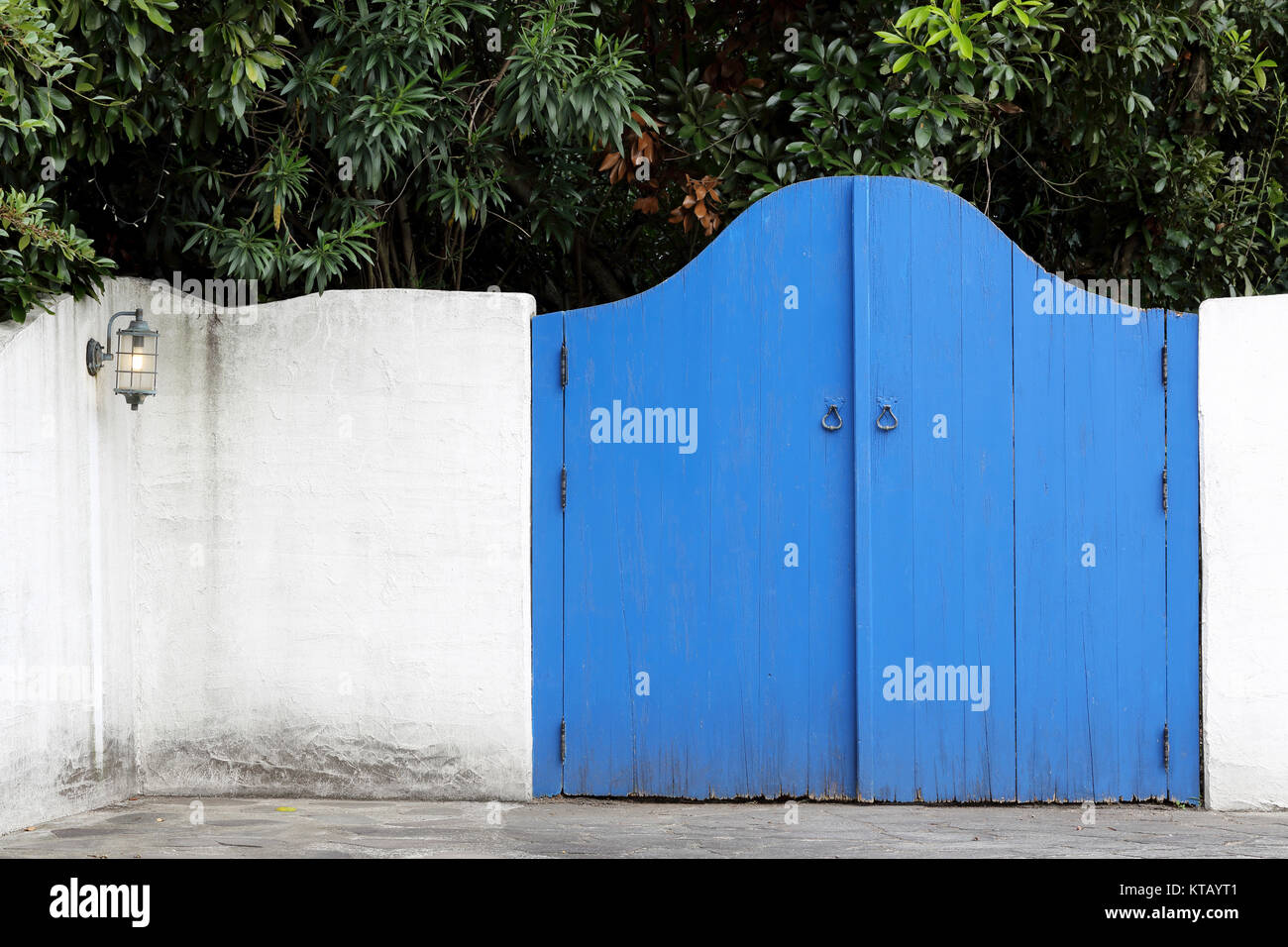 Old wooden blue gateway with white wall Stock Photo - Alamy