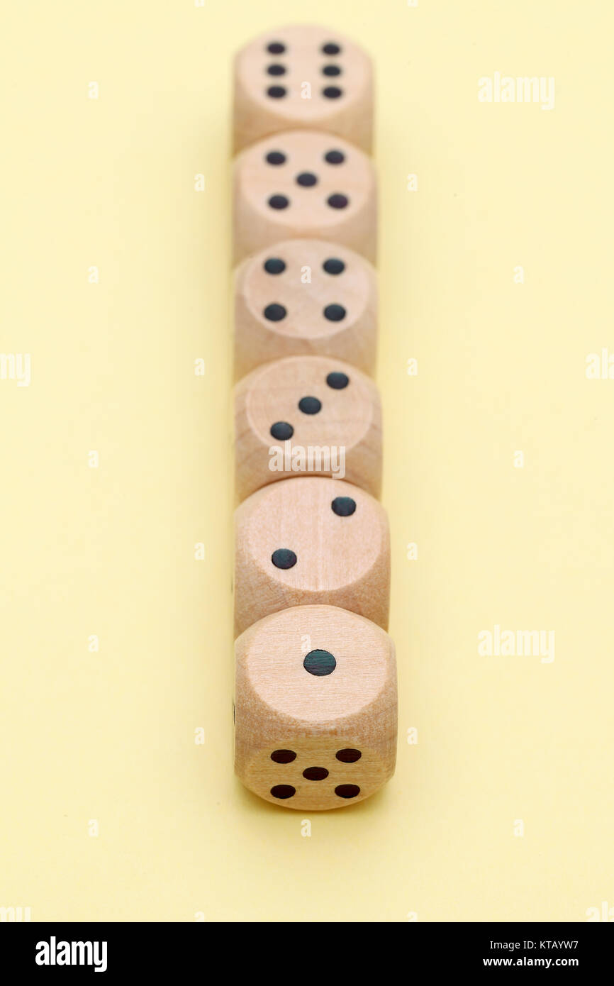 Wooden dice in a row on yellow background Stock Photo - Alamy