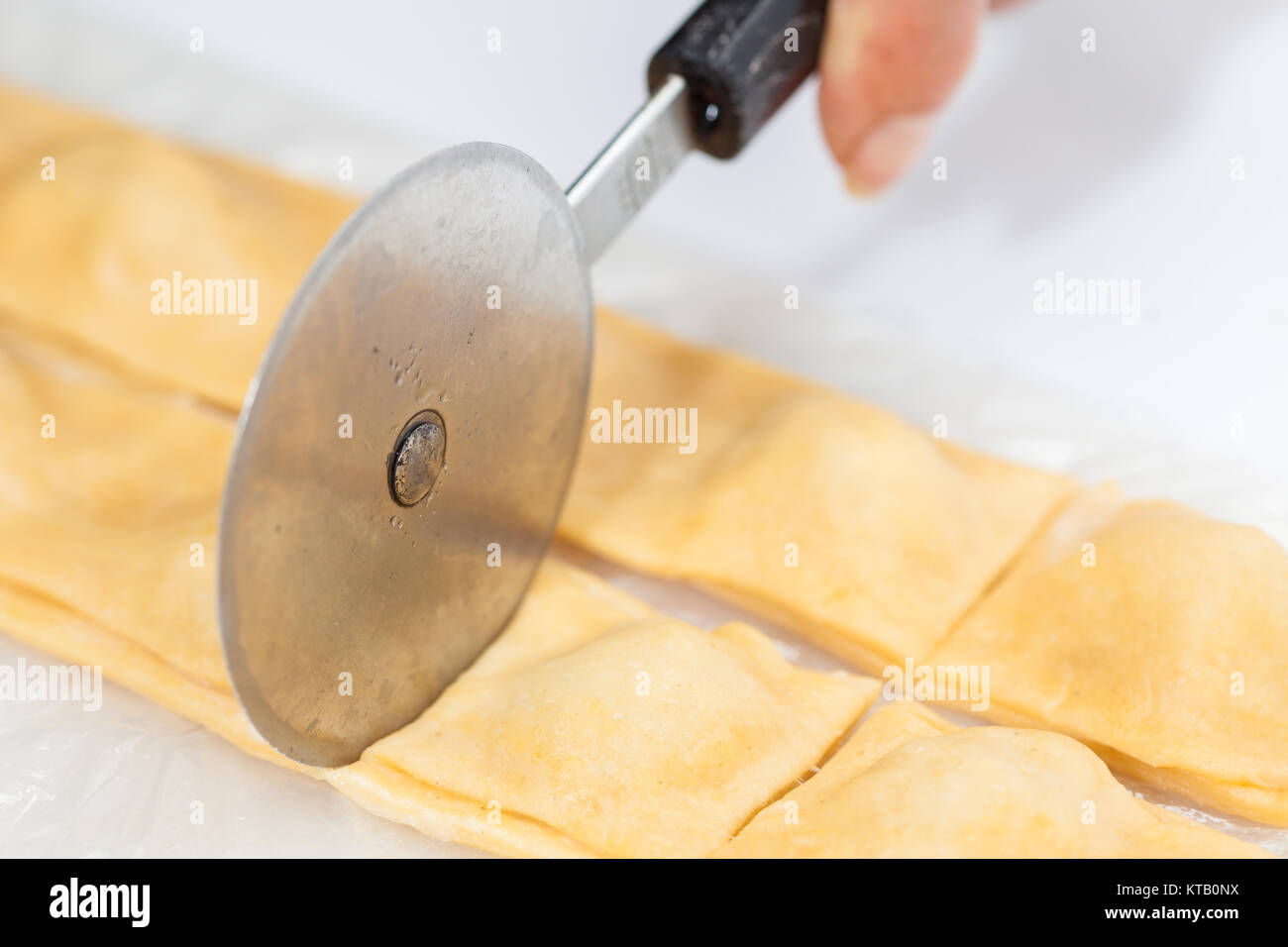 Ravioli Preparation : Cutting the stuffed ravioli strips Stock Photo ...