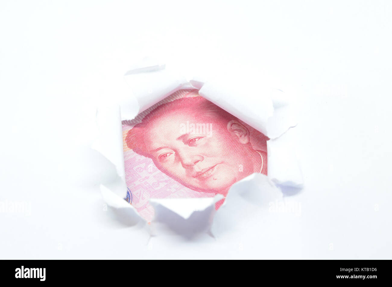 China currency through torn white paper Stock Photo - Alamy